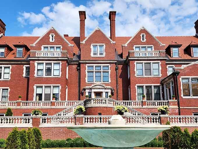 This mansion's red brick elegance and white balustrades create a Downton Abbey moment right here at home.