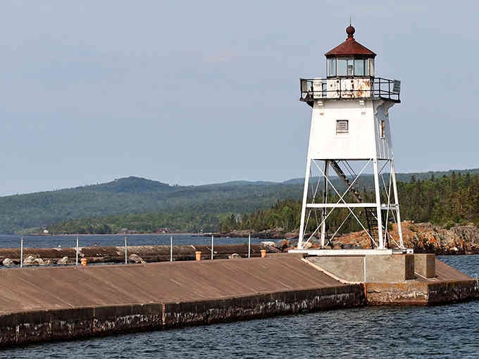 This delicate white sentinel stands guard at harbor's end, its skeletal frame elegant against Superior's endless blue horizon.
