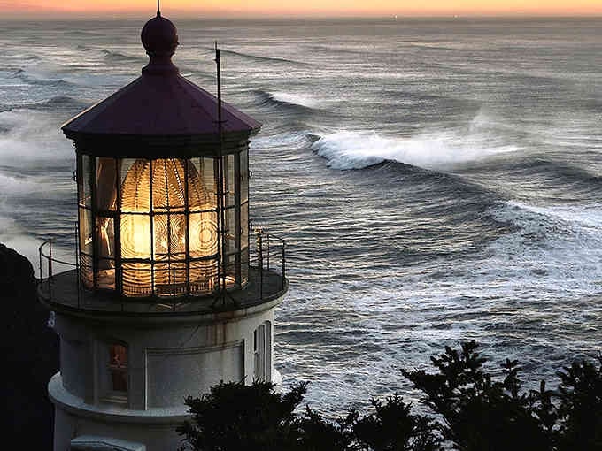 That golden light piercing through the lighthouse lens at sunset creates pure magic against the crashing waves below.