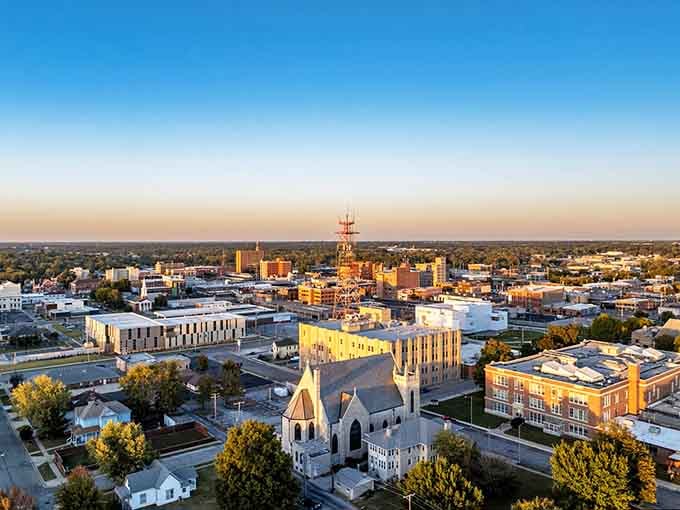 Golden hour bathes this town in warm light, revealing church steeples and possibilities stretching toward the horizon.