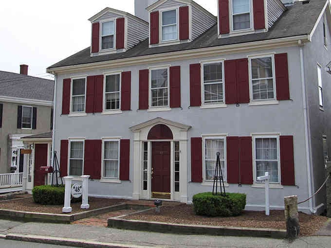 Classic New England architecture with those crisp red shutters that make every house look like a postcard.