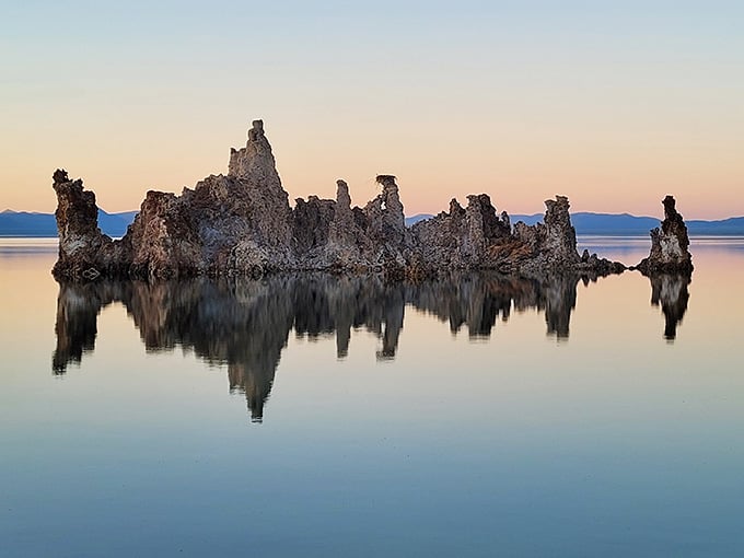 Sunset paints these ancient tufa towers in pastels, creating reflections that look like nature's own Rorschach test.