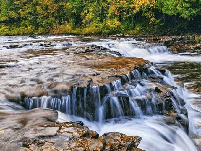 Water cascades over ancient rock in perfect layers, creating nature's own staircase that never gets old to watch.
