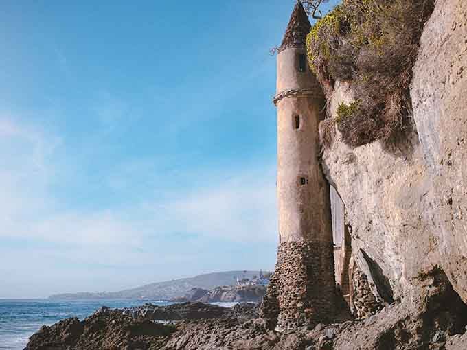 A stone tower rises from the rocky beach like something Rapunzel herself might have called home.