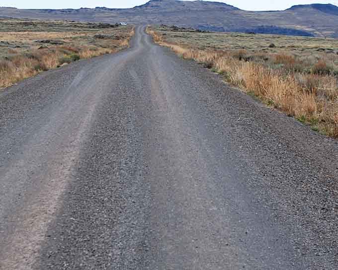 This gravel road stretches toward distant mountains like the opening scene of every great Western movie.