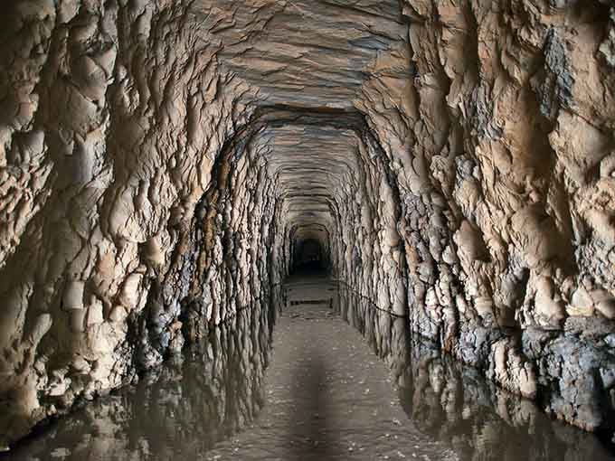 Hand-carved stone walls stretch into cool darkness, a testament to ambition and perseverance from another era entirely.