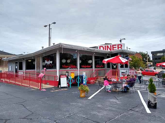 Outdoor seating with red umbrellas and a patriotic flag waving overhead makes every meal feel like a neighborhood celebration.