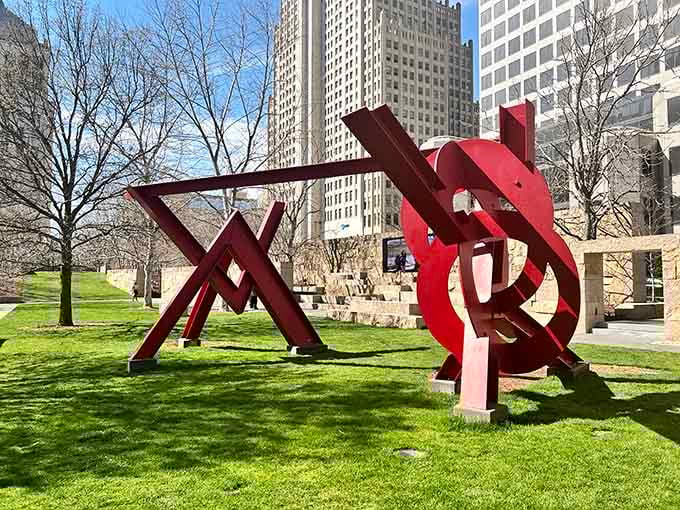 Bold red beams slice through the urban landscape, proving that modern art and city skylines make excellent neighbors.