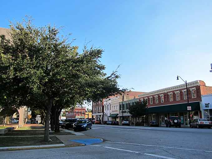 Morning light bathes the town square where mature trees provide shade for leisurely strolls through this peaceful community.