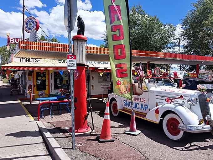 Classic Route 66 charm meets quirky Americana with vintage cars and colorful flags waving in the breeze.