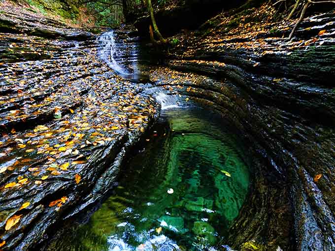 Nature's own swimming pool sparkles emerald green, surrounded by layered stone that tells stories older than memory.