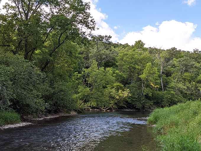 The gentle river curves through lush greenery, offering peace that money simply can't buy.