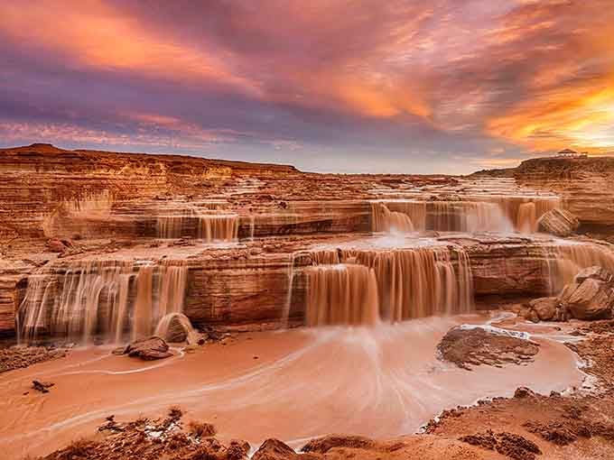 Sunset paints the sky in sherbet colors while terraced falls create nature's own infinity pool in the wilderness.