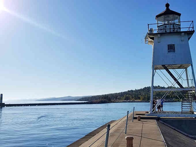 The breakwater stretches like a concrete runway, leading adventurous souls straight to this charming lakeside guardian's doorstep.