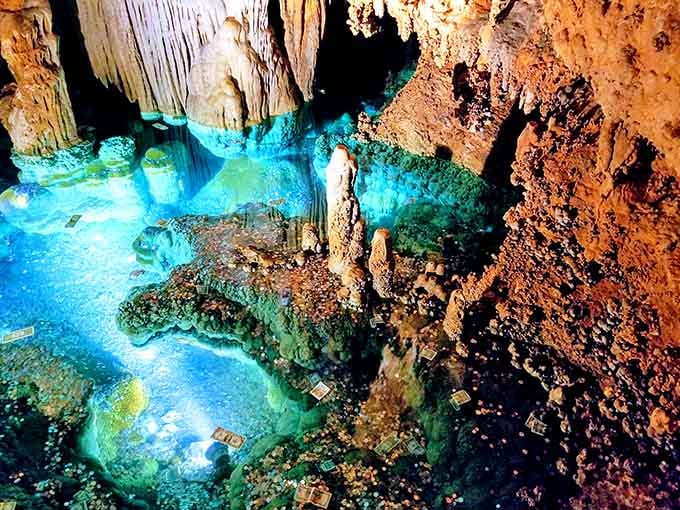 Stalactites drip like honey frozen in time, their golden hues illuminated against turquoise waters below.