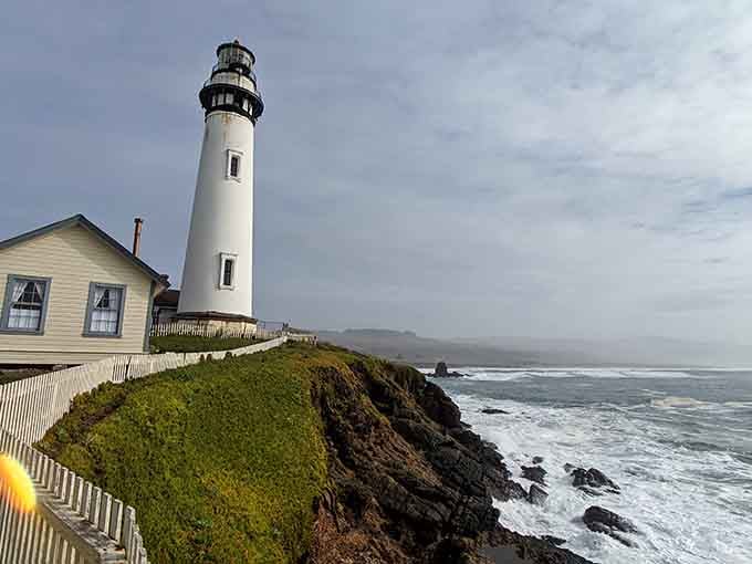 The keeper's cottage nestled beside this towering lighthouse creates a scene straight from a maritime painting come alive.