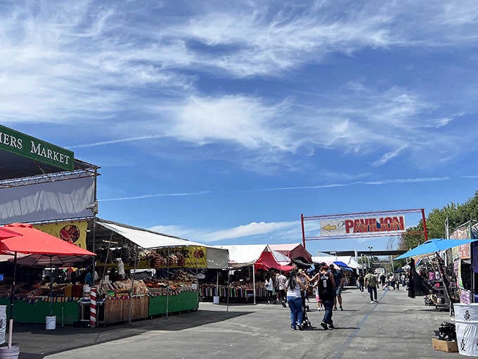 The Farmers Market sign and colorful pavilion create a festive atmosphere that draws crowds every weekend.
