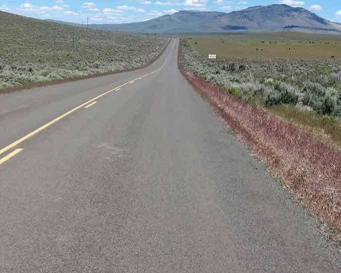 Wide-open sagebrush country meets endless sky on a road that feels like driving through pure freedom.