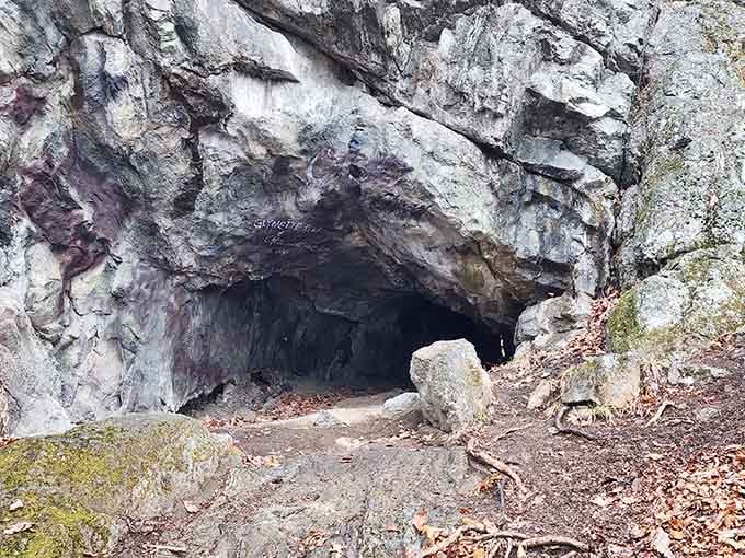 This mysterious opening beckons like something from Tolkien—moss-covered stones guard the entrance to nature's secret chamber.