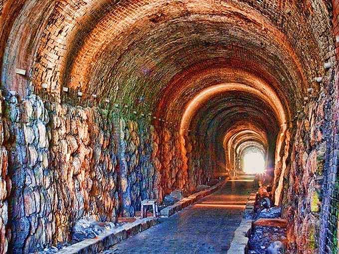 The rainbow of mineral stains on these ancient tunnel walls creates an underground art gallery nobody planned.