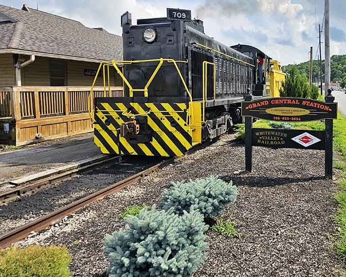 The Grand Central Station sign welcomes you to adventure, where yellow-striped engines wait beside charming wooden platforms.