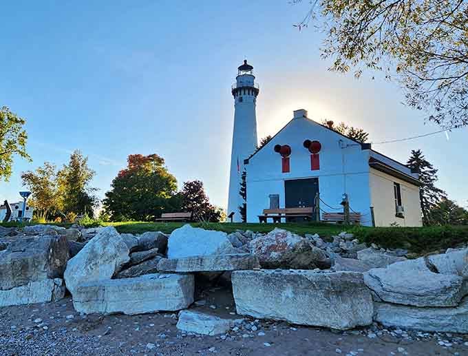 Those weathered rocks at the shoreline tell stories of countless storms while the lighthouse stands watch like a faithful guardian.