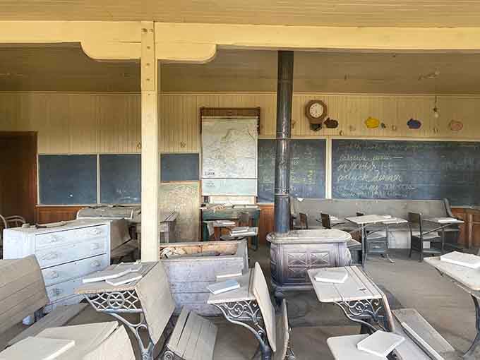 The schoolhouse interior feels like the students just stepped out for recess and never came back, desks frozen in time.