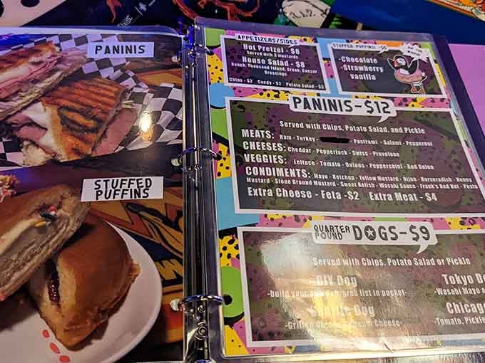 The menu speaks '80s with playful fonts, offering paninis and quarter dogs to fuel your gaming marathon adventures.