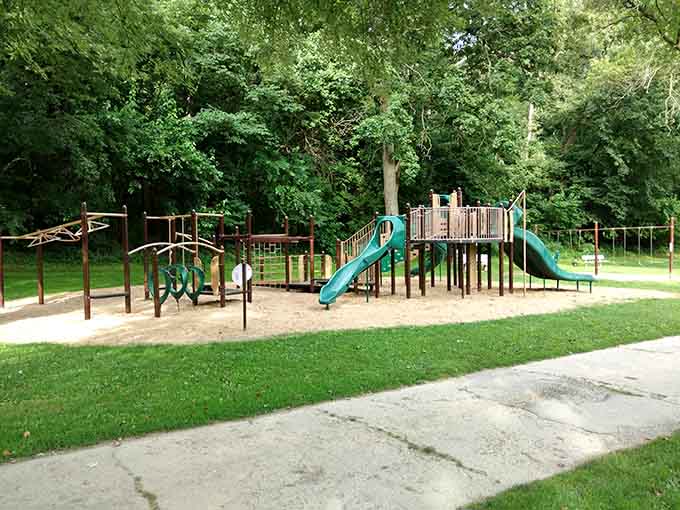 Modern playground equipment meets old-growth trees in a park where kids can actually be kids without scheduled activities.