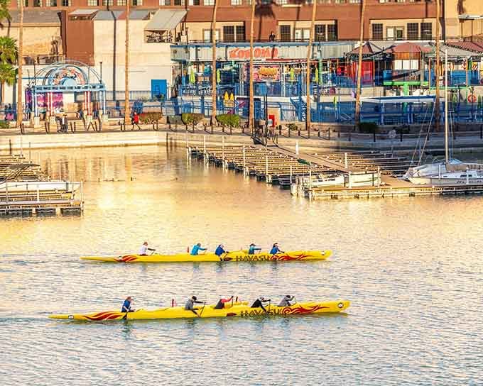 Kayakers glide past the BlueWater Resort like colorful water bugs, proving that exercise can actually look peaceful and fun.