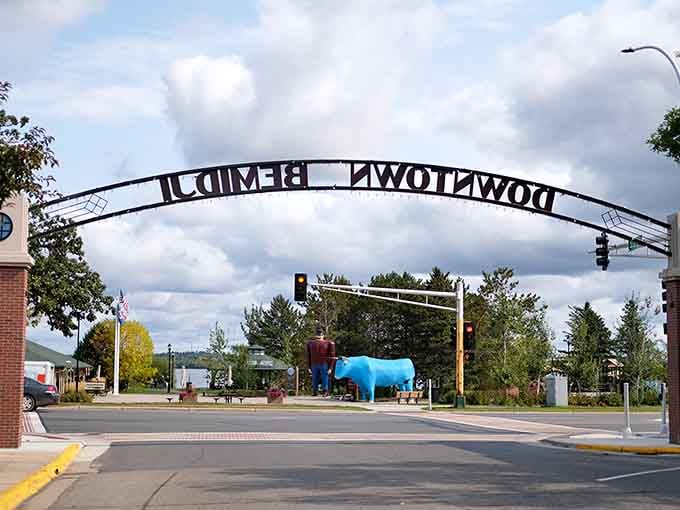 The "Downtown Bemidji" arch frames these legendary figures like they're starring in their own Main Street production.