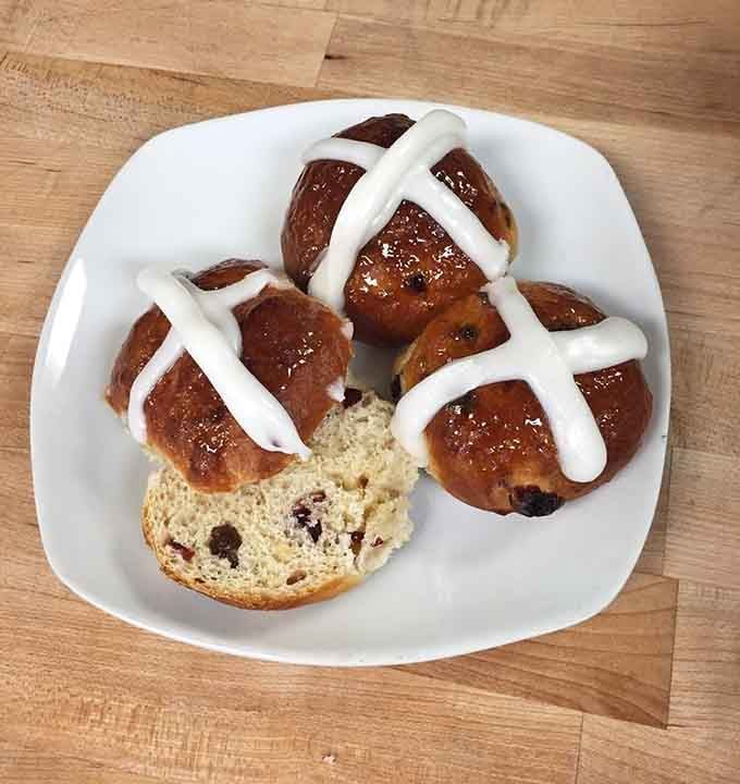 Hot cross buns with that iconic icing cross, soft and studded with fruit like Easter morning perfection.