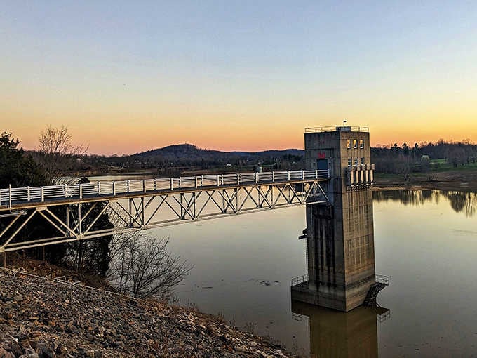 Dawn breaks over the dam's outlet tower, painting the sky in shades that would make Monet jealous.