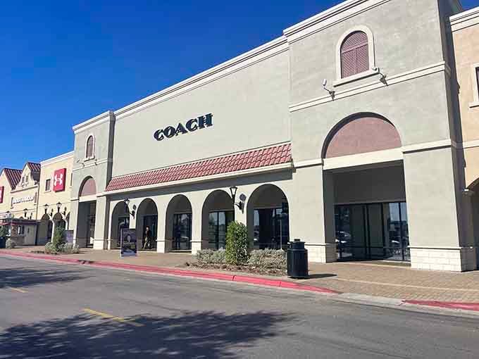Coach's clean storefront beckons with those classic arches, promising leather goods at prices that won't hurt.