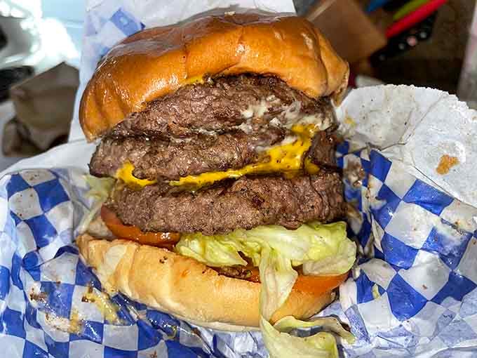 The Triple Fatboy Burger towers like a delicious skyscraper that requires architectural planning to eat.