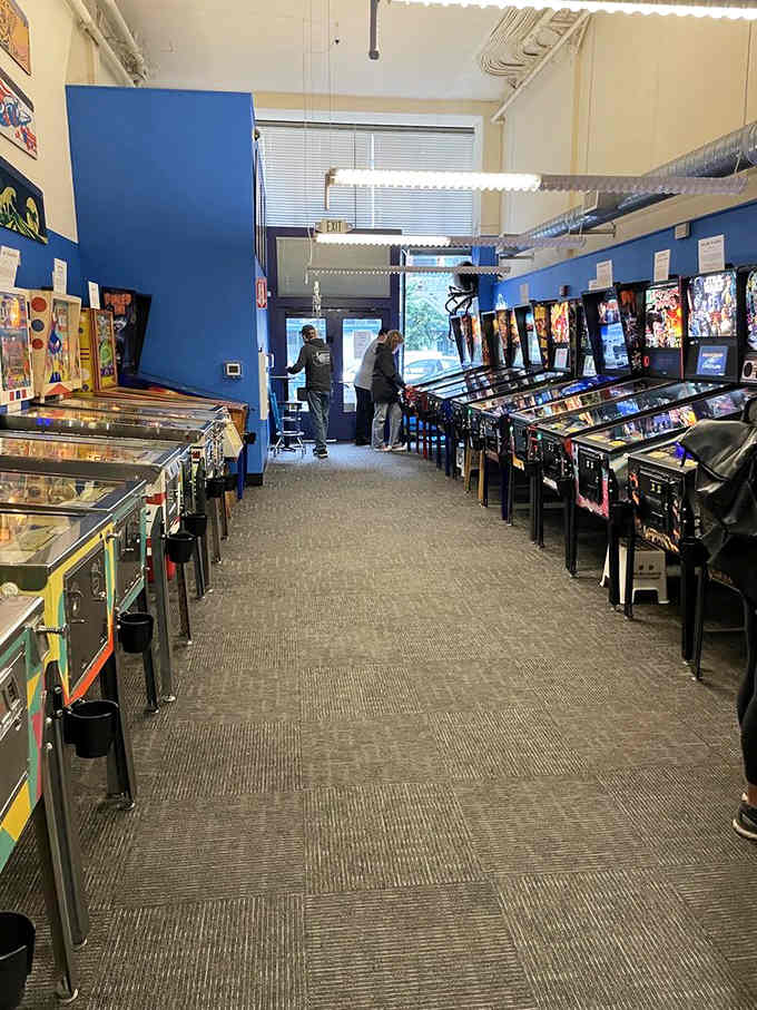 The blue walls and industrial ceiling create the perfect backdrop for what matters most: endless silver ball action.