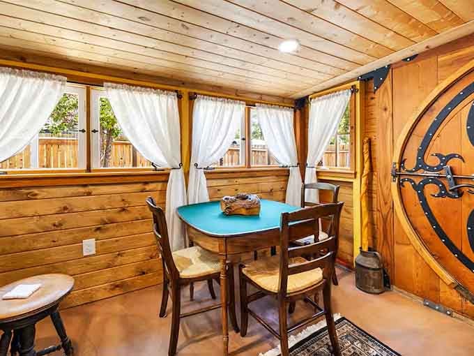 White curtains frame windows in this dining nook where second breakfast becomes absolutely mandatory.
