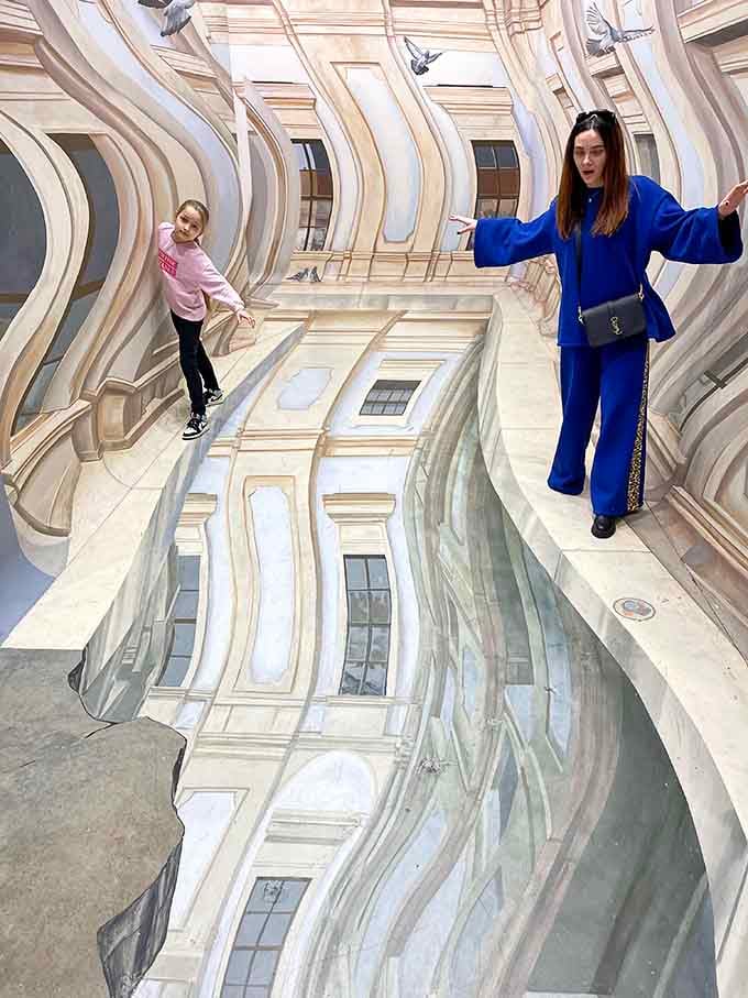 Walking across what appears to be a European building facade requires zero passport paperwork, maximum courage.