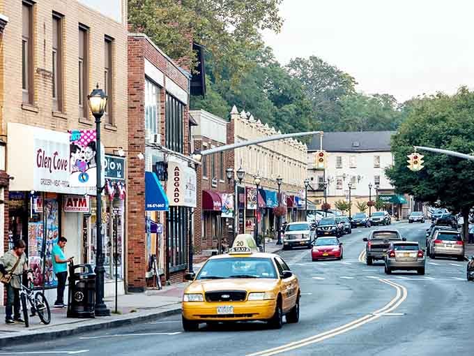 Classic yellow cabs cruise through downtown Glen Cove, where small-town charm meets waterfront sophistication in perfect harmony.