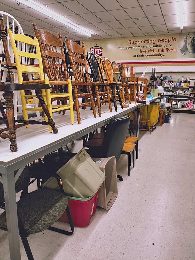 Chairs stacked like a wooden Jenga tower, each one waiting to find its perfect dining room match.