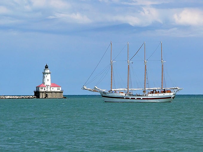 A classic tall ship glides past this red-roofed beauty, creating a scene straight out of a maritime painting.