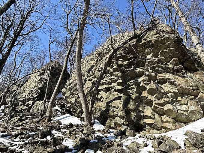 These towering rock formations stand like ancient sentinels, their weathered faces telling stories older than your favorite history book.