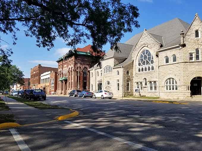 Architectural gems line quiet streets where Romanesque stonework meets small-town charm under leafy canopies.