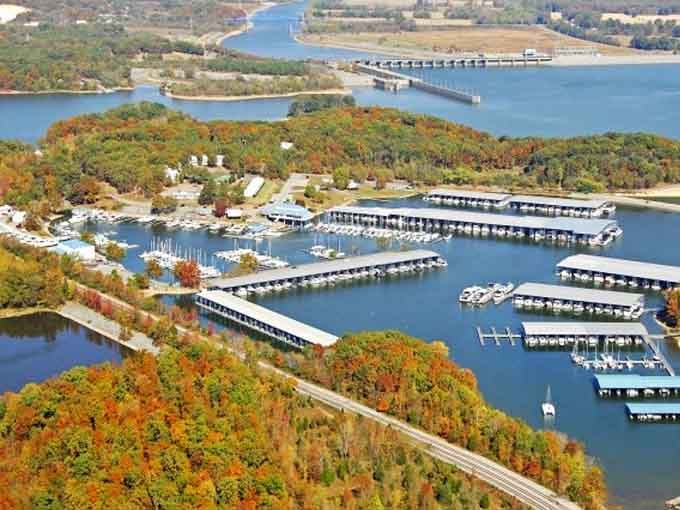 Autumn colors frame this marina like nature's showing off, with boats lined up like they're waiting for their close-up.
