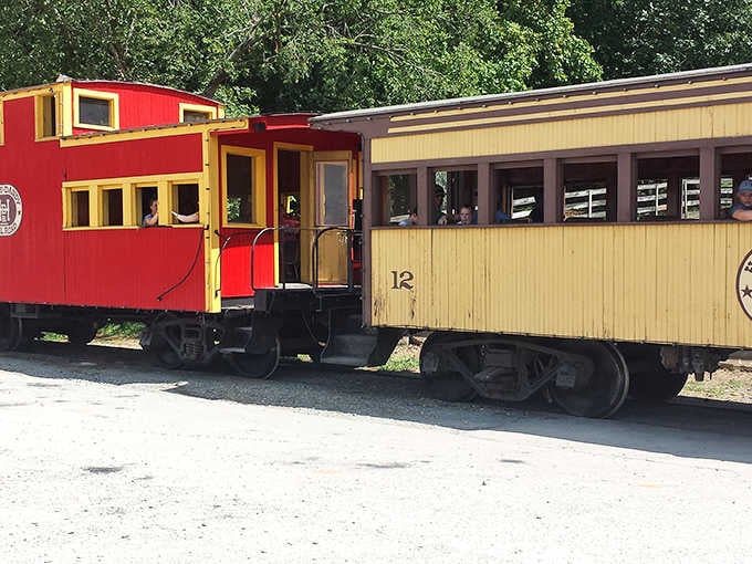 The classic red caboose paired with that cream-colored passenger car creates a postcard-perfect moment you'll want to remember.