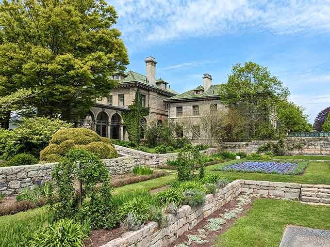 Terraced gardens cascade like a green stairway, framing this elegant mansion in pure coastal sophistication.
