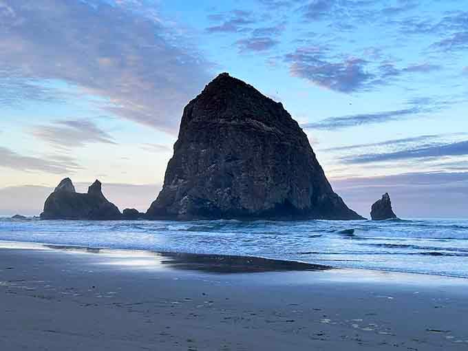 Pastel clouds streak overhead while waves whisper secrets to the shore, creating Oregon's most photographed coastal moment.