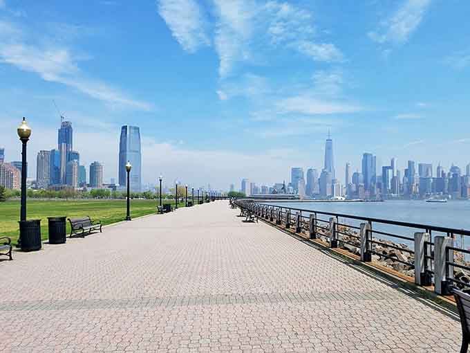 The paved walkway stretches endlessly toward the city, inviting leisurely strolls with postcard-perfect scenery at every turn.