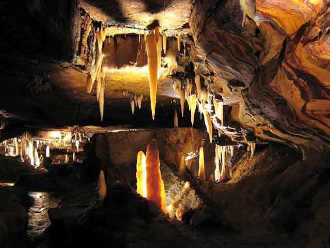Golden stalactites hang like chandeliers in an underground ballroom where time moves at a drip.