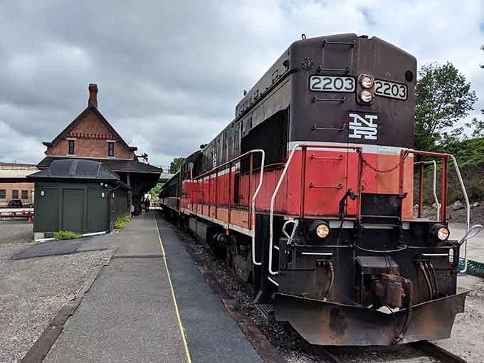 This red and black diesel locomotive stands proudly at the platform, a workhorse from America's industrial railroad era.
